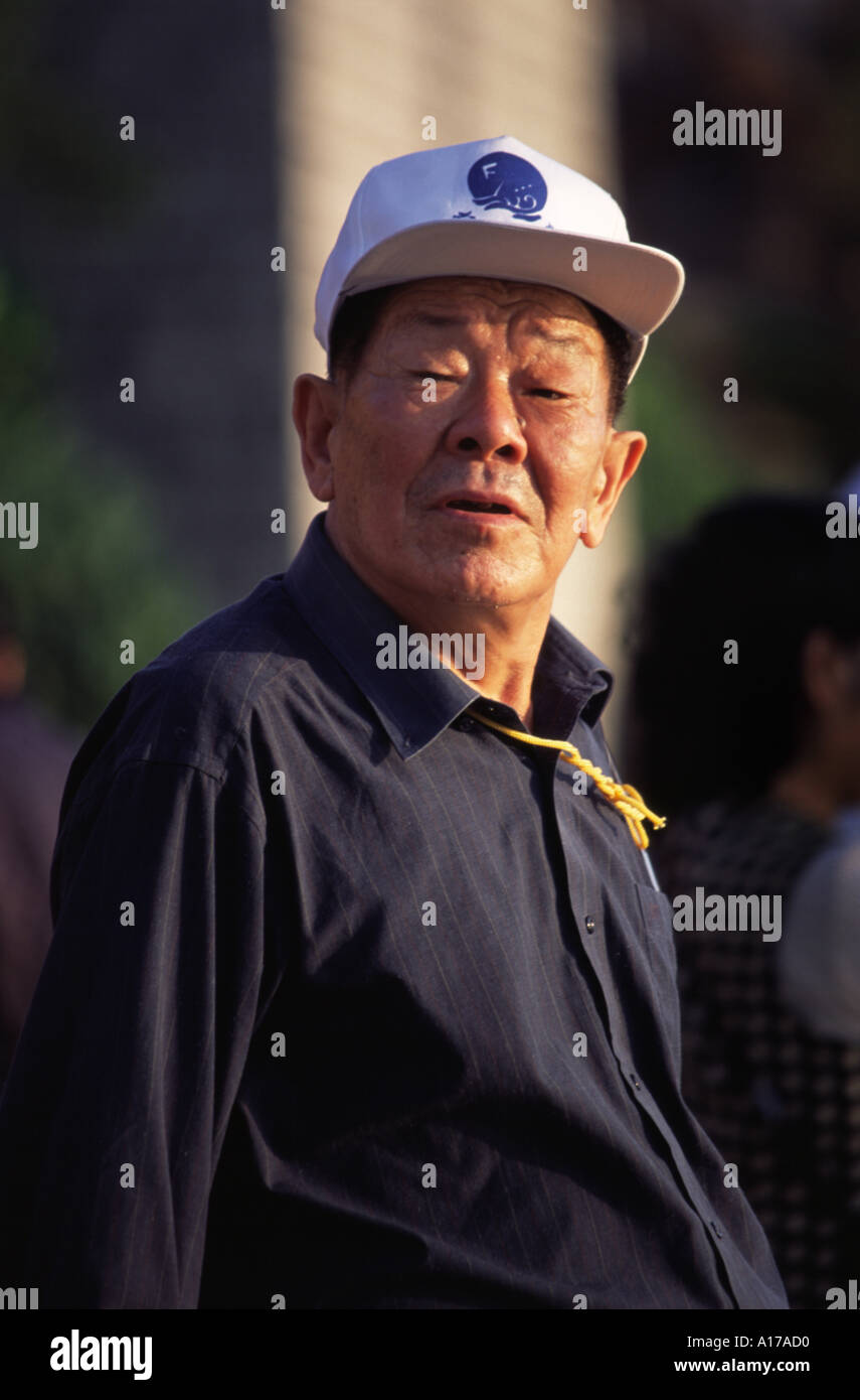 Old Chinese man with white cap looks on Stock Photo - Alamy