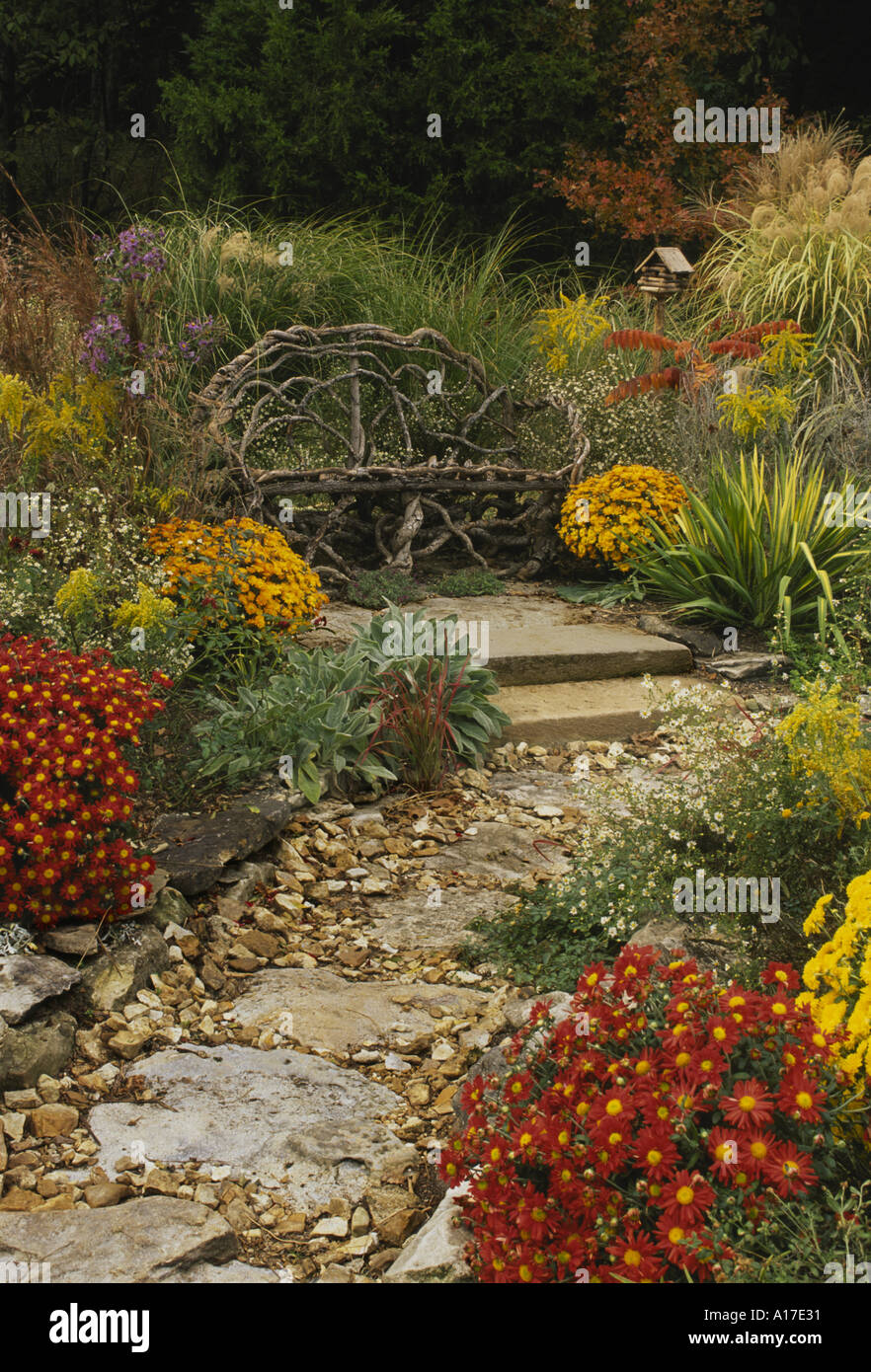 Rustic handmade grapevine built wooden bench in bright fall home flower ...
