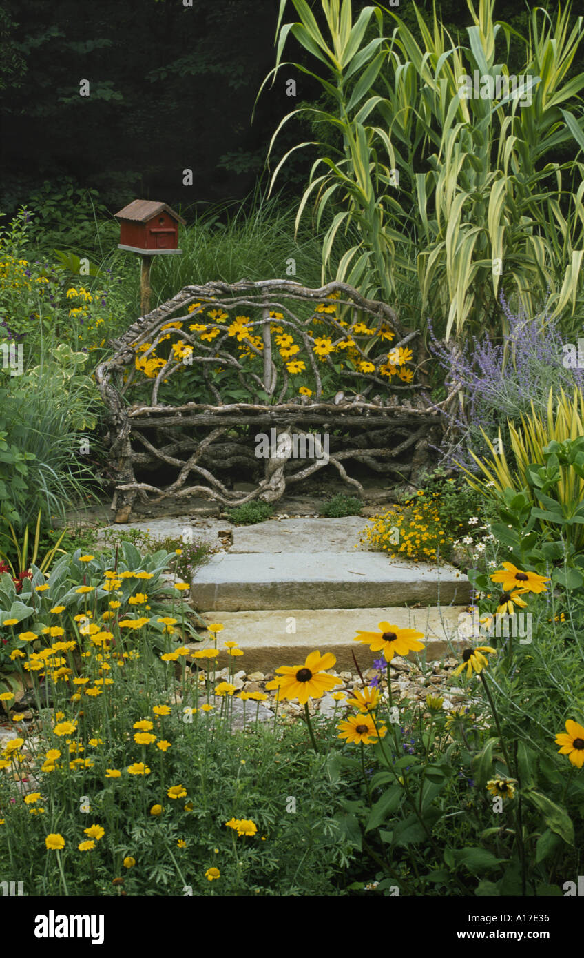 Rustic handmade grapevine bench with flower vine on stone steps and ...