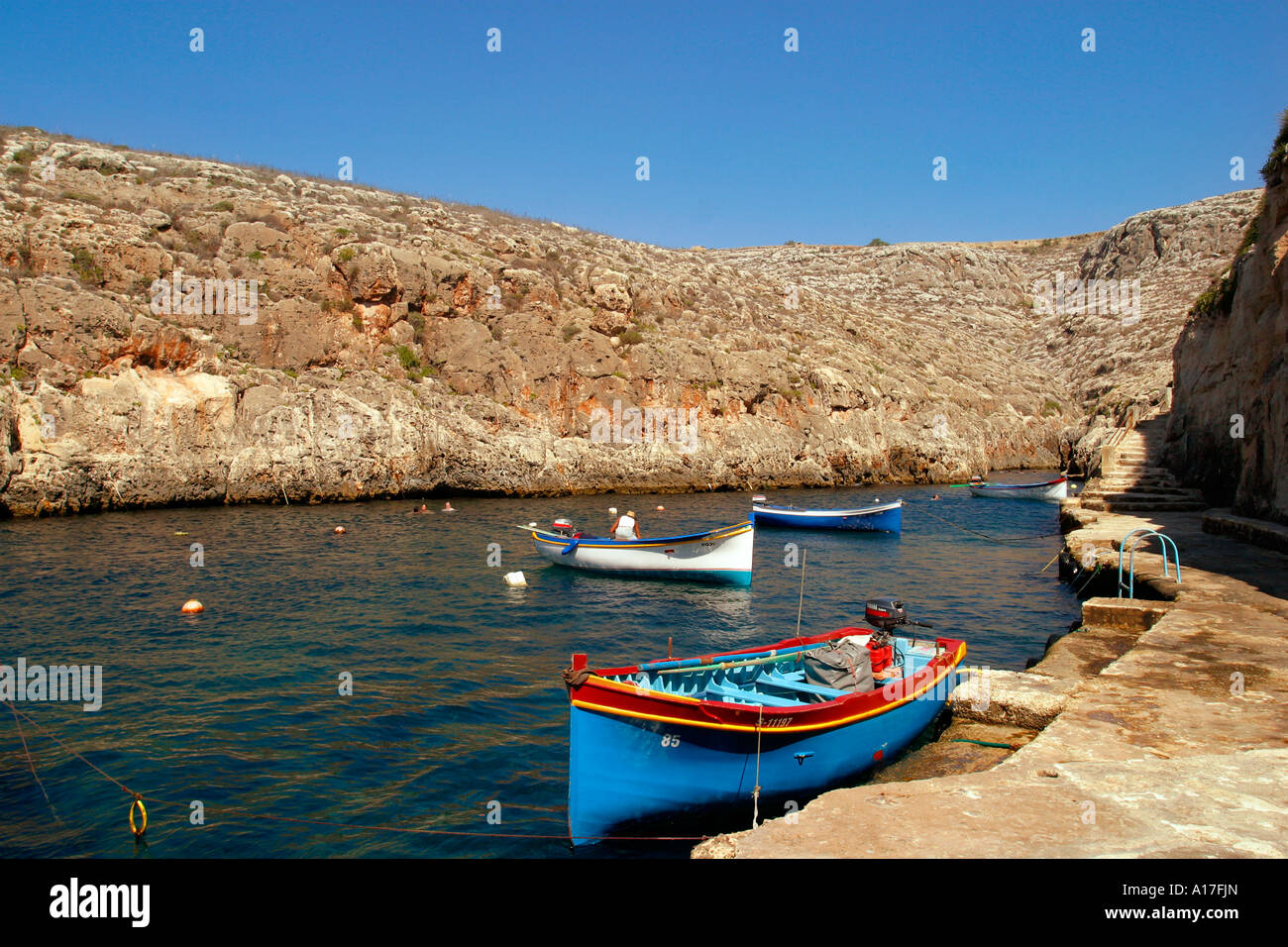 Brightly painted Maltese boats on blue water in summer, Malta Stock ...
