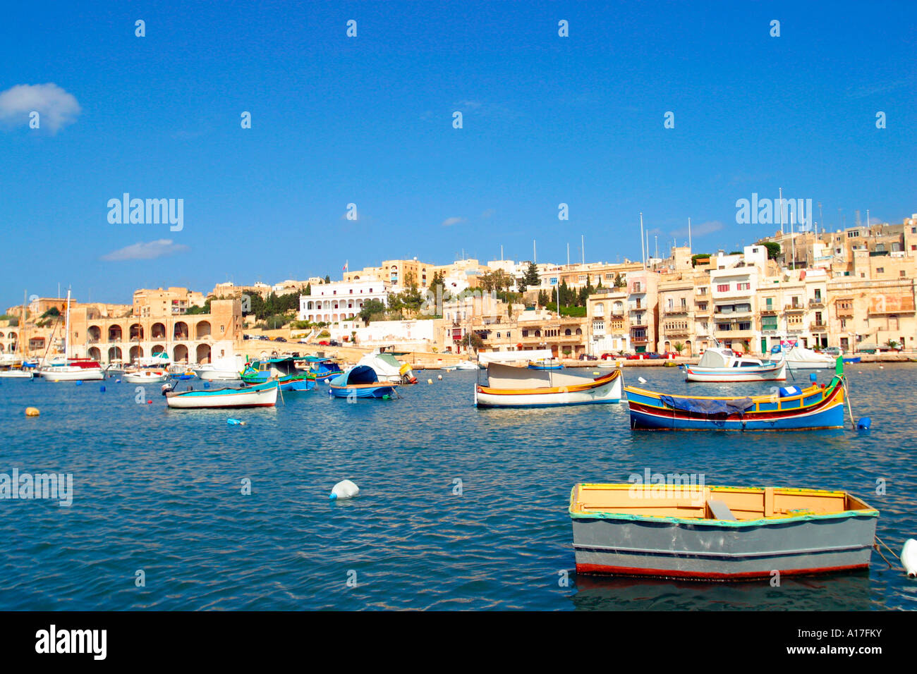 Brightly painted Maltese boats on blue water in summer, Malta Stock ...