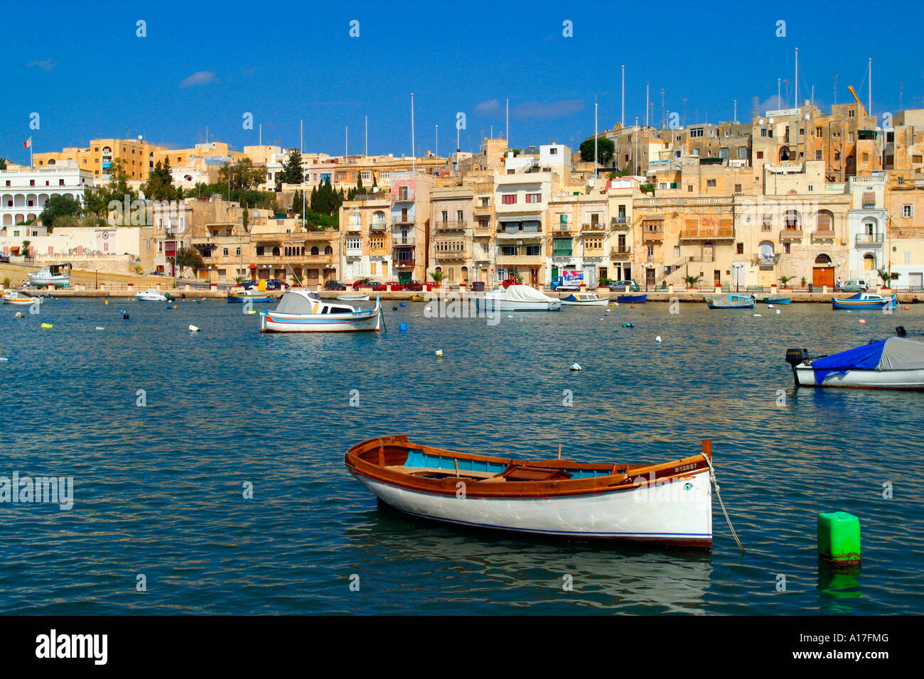 Brightly painted Maltese boats on blue water in summer, Malta Stock ...