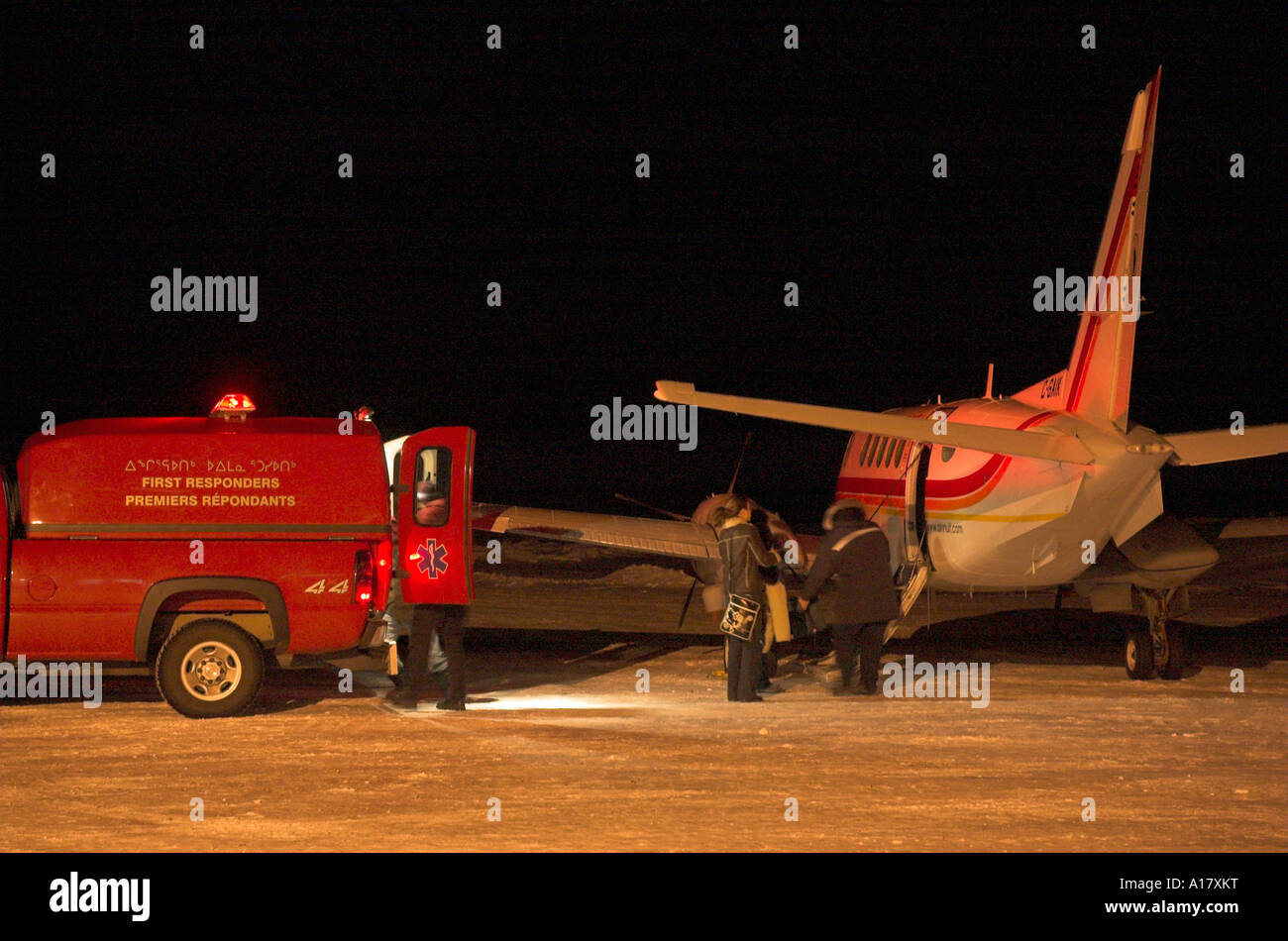 A group of doctors loading a patient on a stretcher into a plane during ...