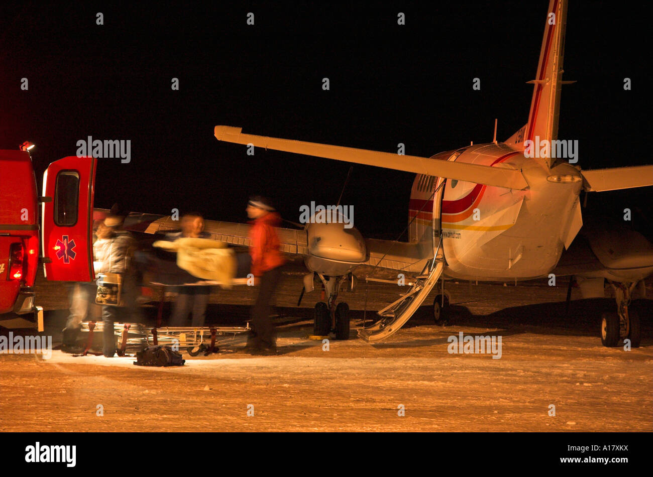 A group of doctors loading a patient on a stretcher into a plane during ...