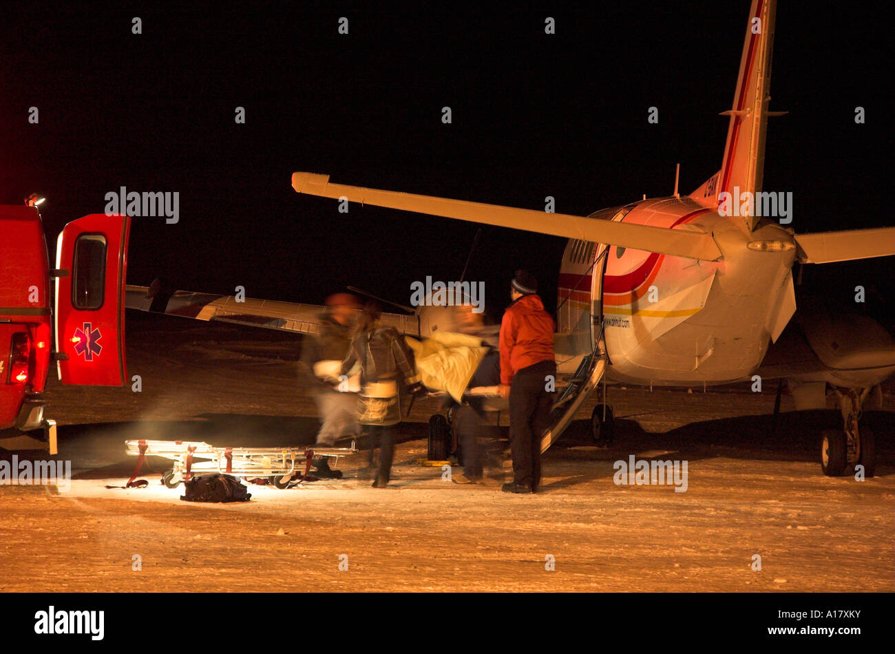 A group of doctors loading a patient on a stretcher into a plane during ...