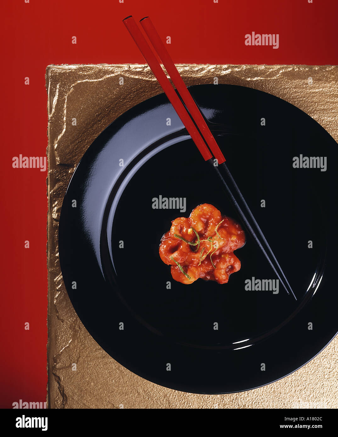 ORIENTAL CURRIED PRAWNS WITH RED CHOP STICKS ON BLACK PLATE Stock Photo ...