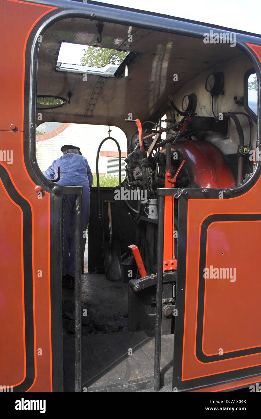 vertical portrait photo of a train driver in the cabin or cockpit of a ...