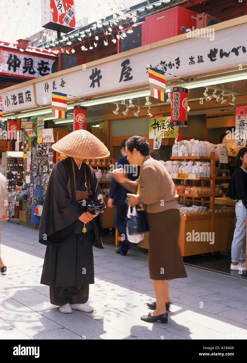 A monk with a bowl begging for alms in the Nakamise of Asakusa Kanon ...