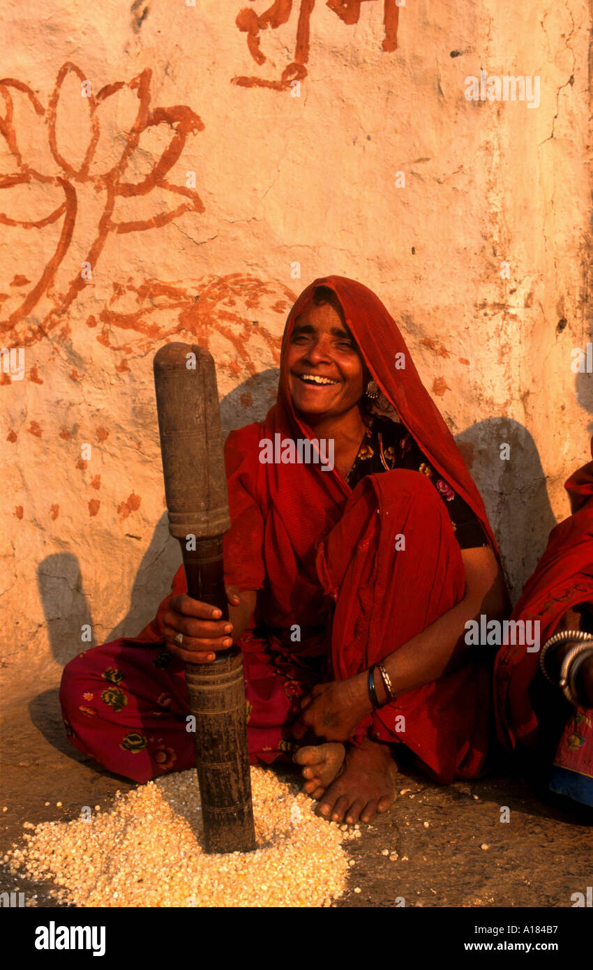 Portrait of woman pounding grain with pestle near Deogarh Rajasthan ...