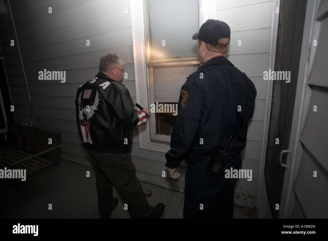 Crime Scene Technician and Detective inspects broken window at the ...