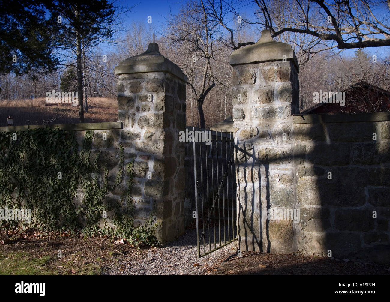 Iron gate by a stone wall Stock Photo - Alamy