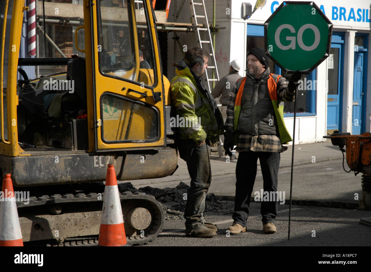 stop go sign and workers at road works Stock Photo - Alamy