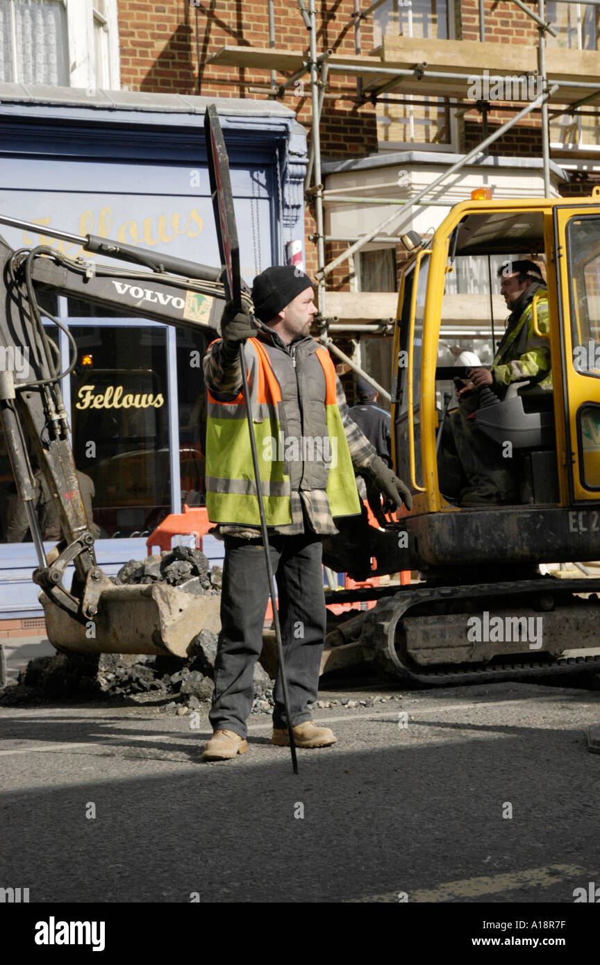 stop go sign and workers at road works Stock Photo - Alamy