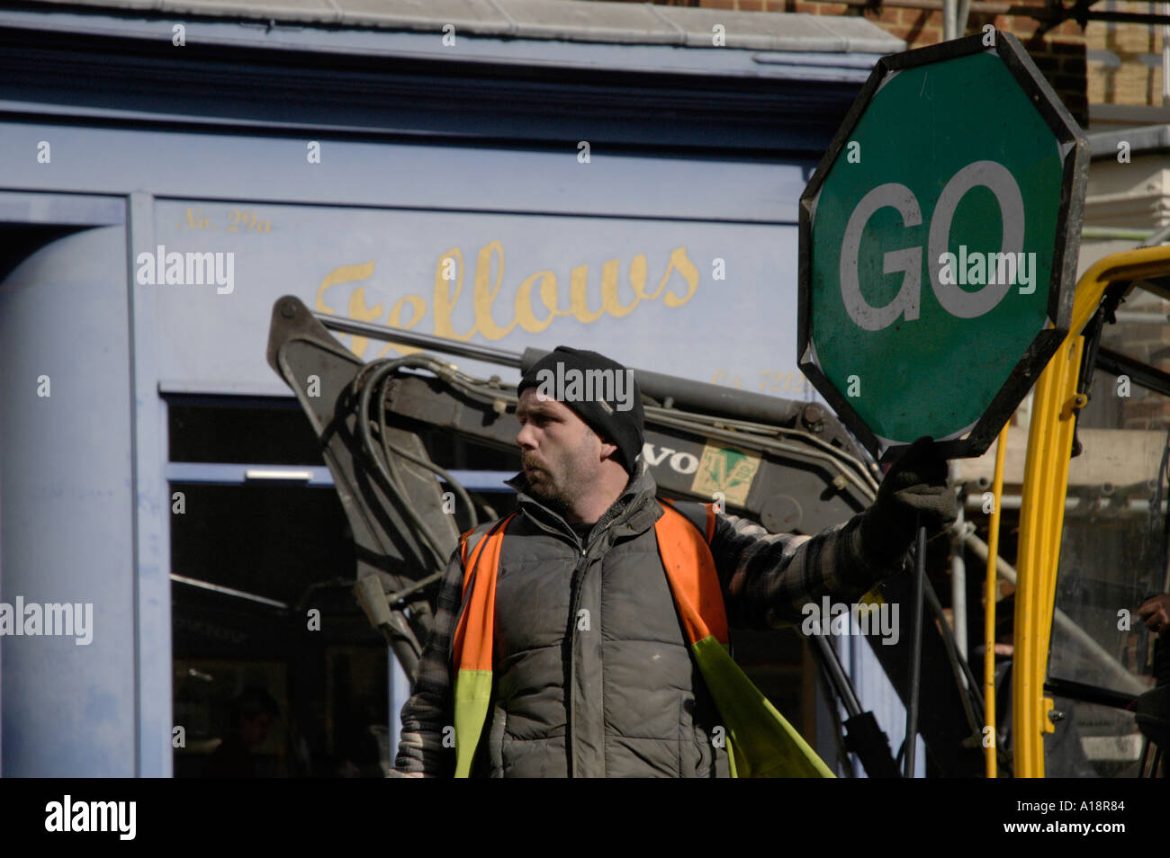 stop go sign and workers at road works Stock Photo - Alamy