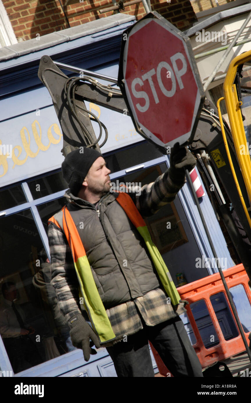 stop go sign and workers at road works Stock Photo - Alamy