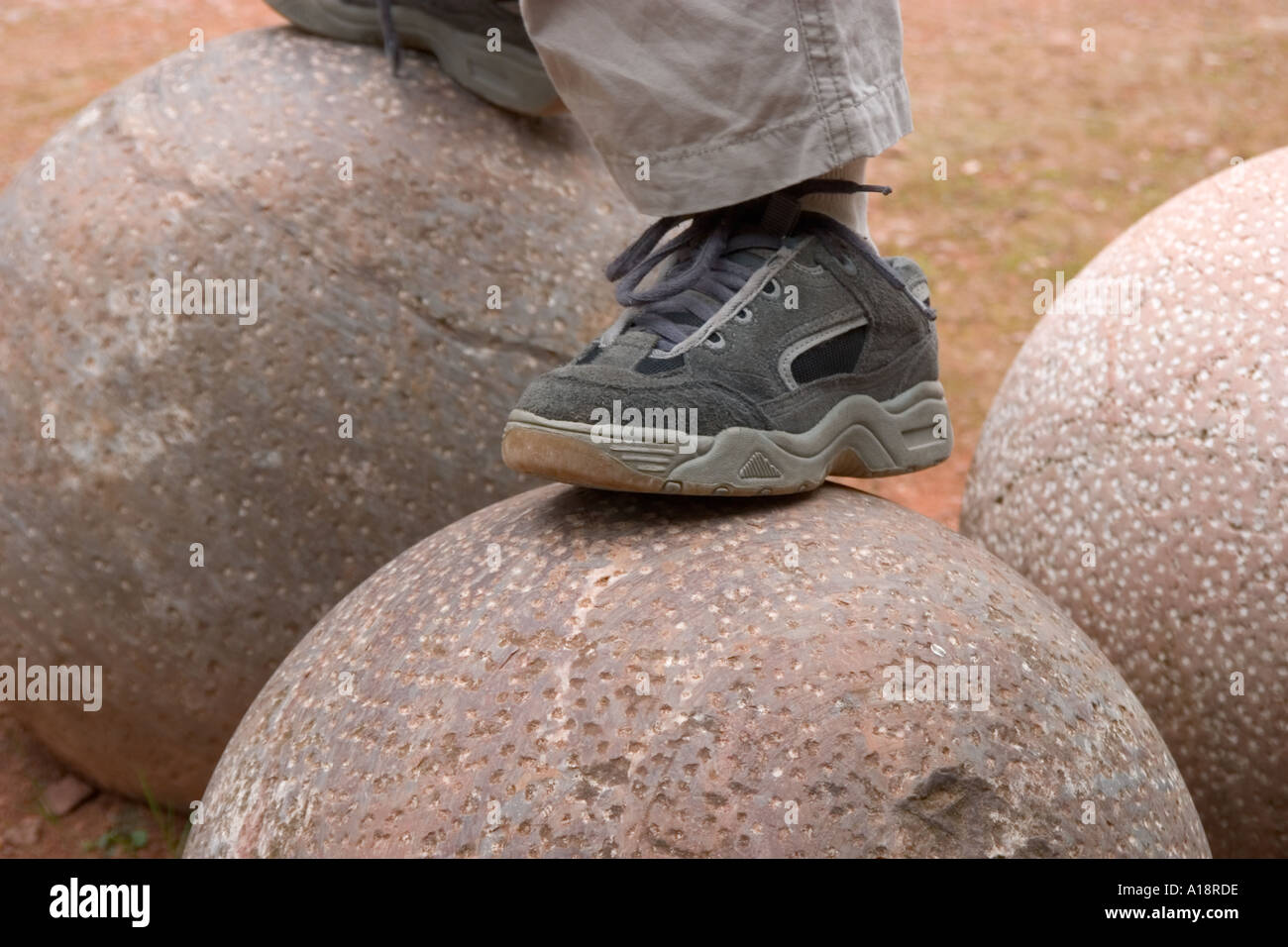Foot stepping on a round stone Stock Photo - Alamy