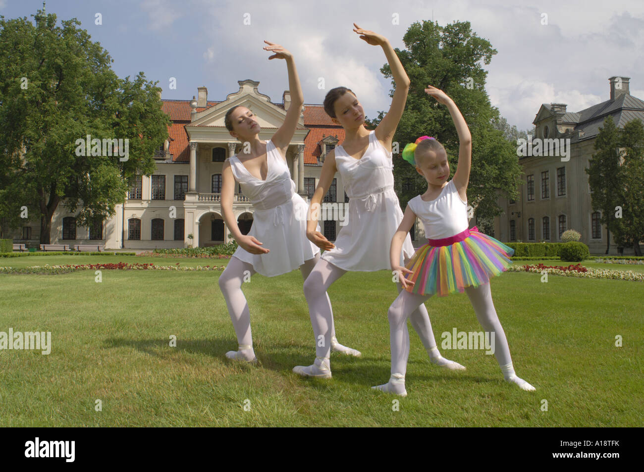 Three young Polish ballet dancers posing outside on a lawn in front of ...