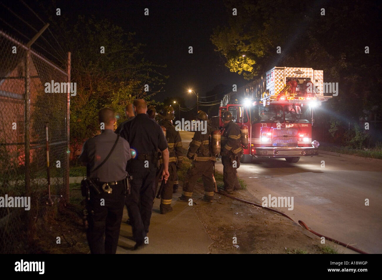 Firefighters police and equipment at the scene of a small fire in ...