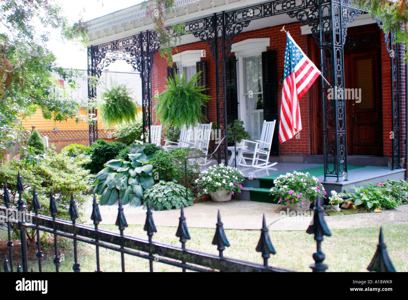 Colonial House with Wrought Iron Fence and American Flag Stock Photo ...