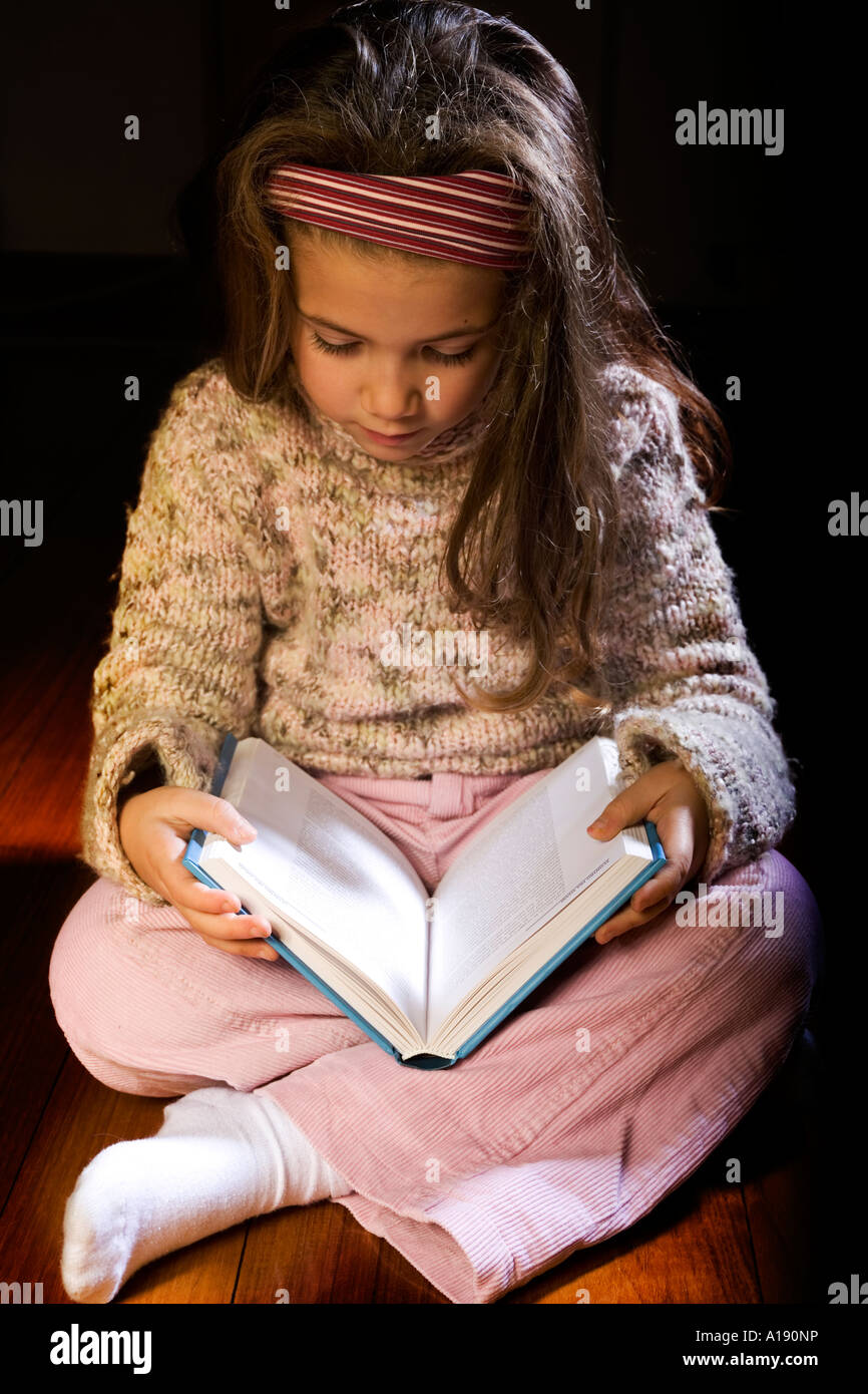 Little 6 years old girl reading a book Stock Photo - Alamy