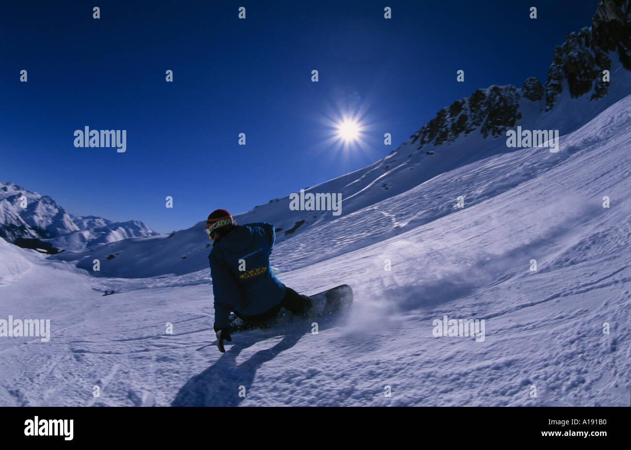 A Snowboarder carving through the snow in Disentis Switzerland Stock ...