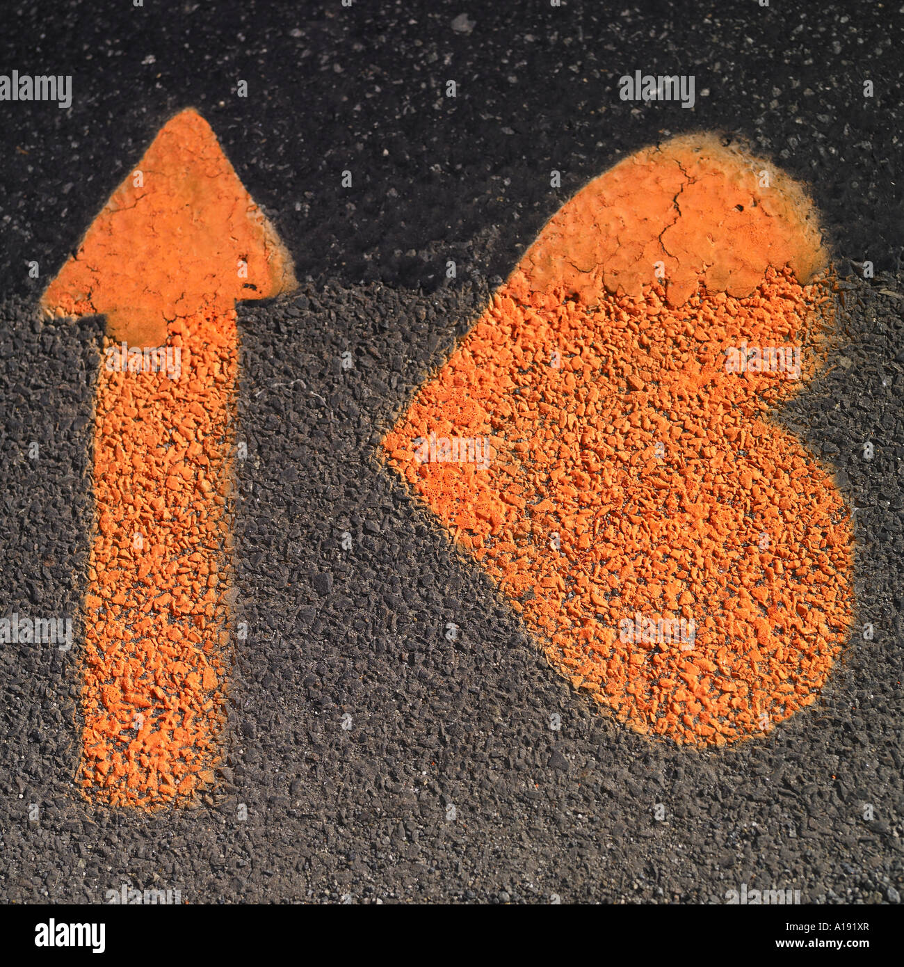 Painted orange signs on the asphalt Stock Photo - Alamy