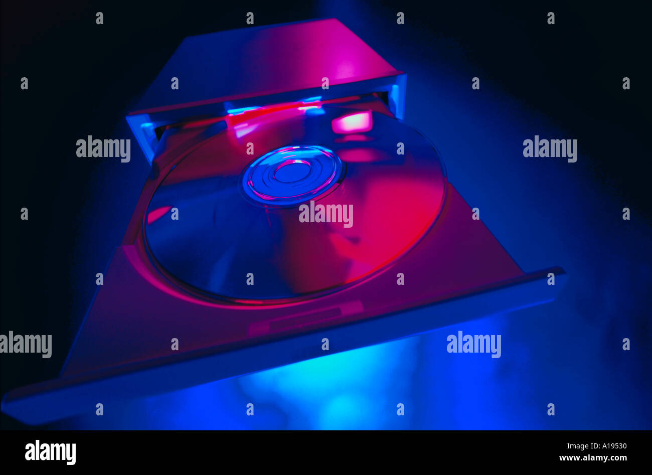 A CD Rom compact disc sitting in the tray of a CD player with purple ...