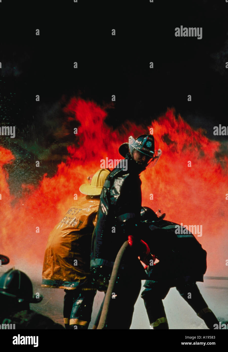 Firefighters fighting fire Stock Photo - Alamy