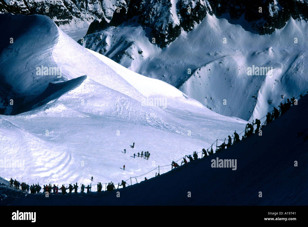 Figures silhouetted walking along the ridge at the top of the Vallee ...
