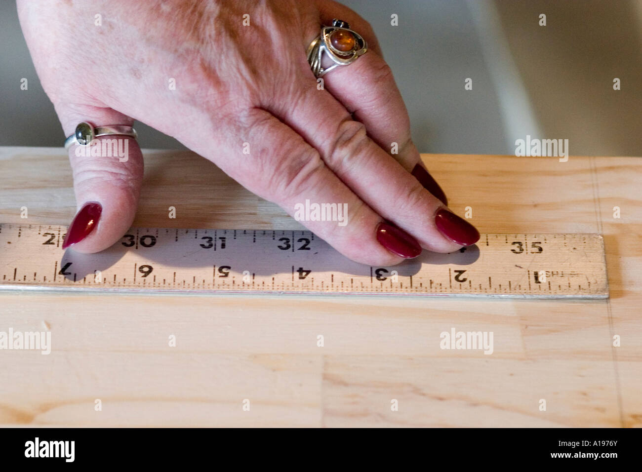 Woman age 64 measuring board for home remodeling project. St Paul ...
