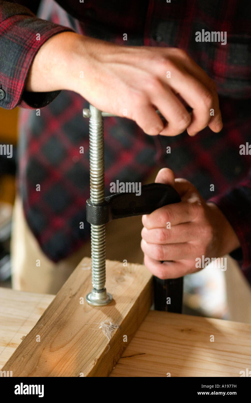 Carpenter clamping guide board to make a straight cut with saw age 36 ...