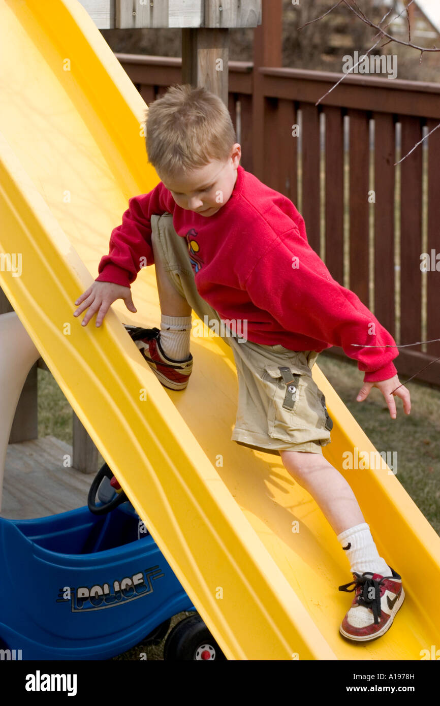 Boy age 5 climbing up slide with grace. St Paul Minnesota USA Stock ...