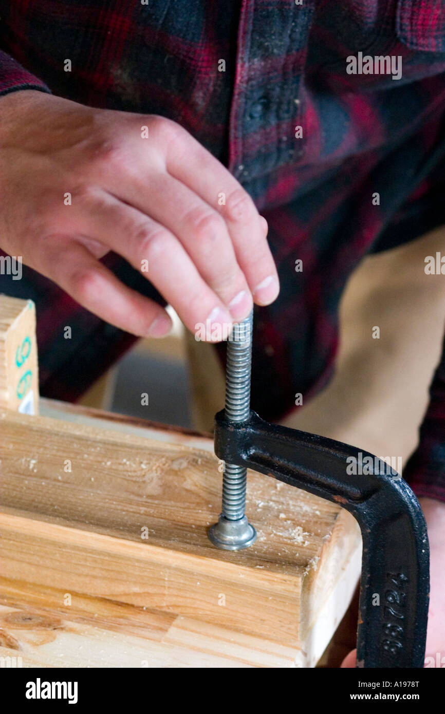 Carpenter clamping guide board to make a straight cut with saw age 36 ...
