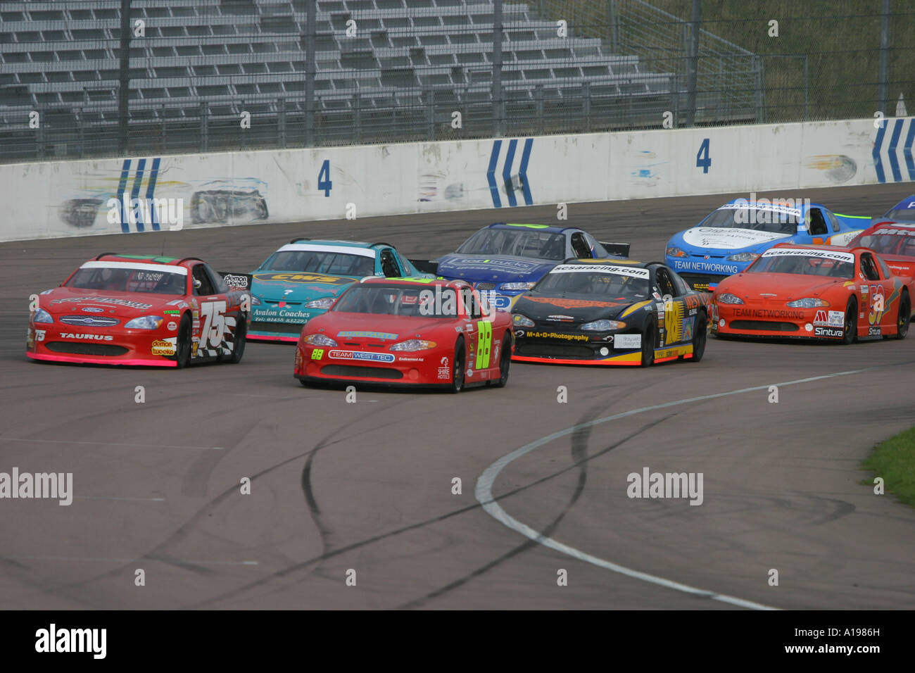V8 Nascar type stock cars racing on a banked oval circuit Stock Photo ...