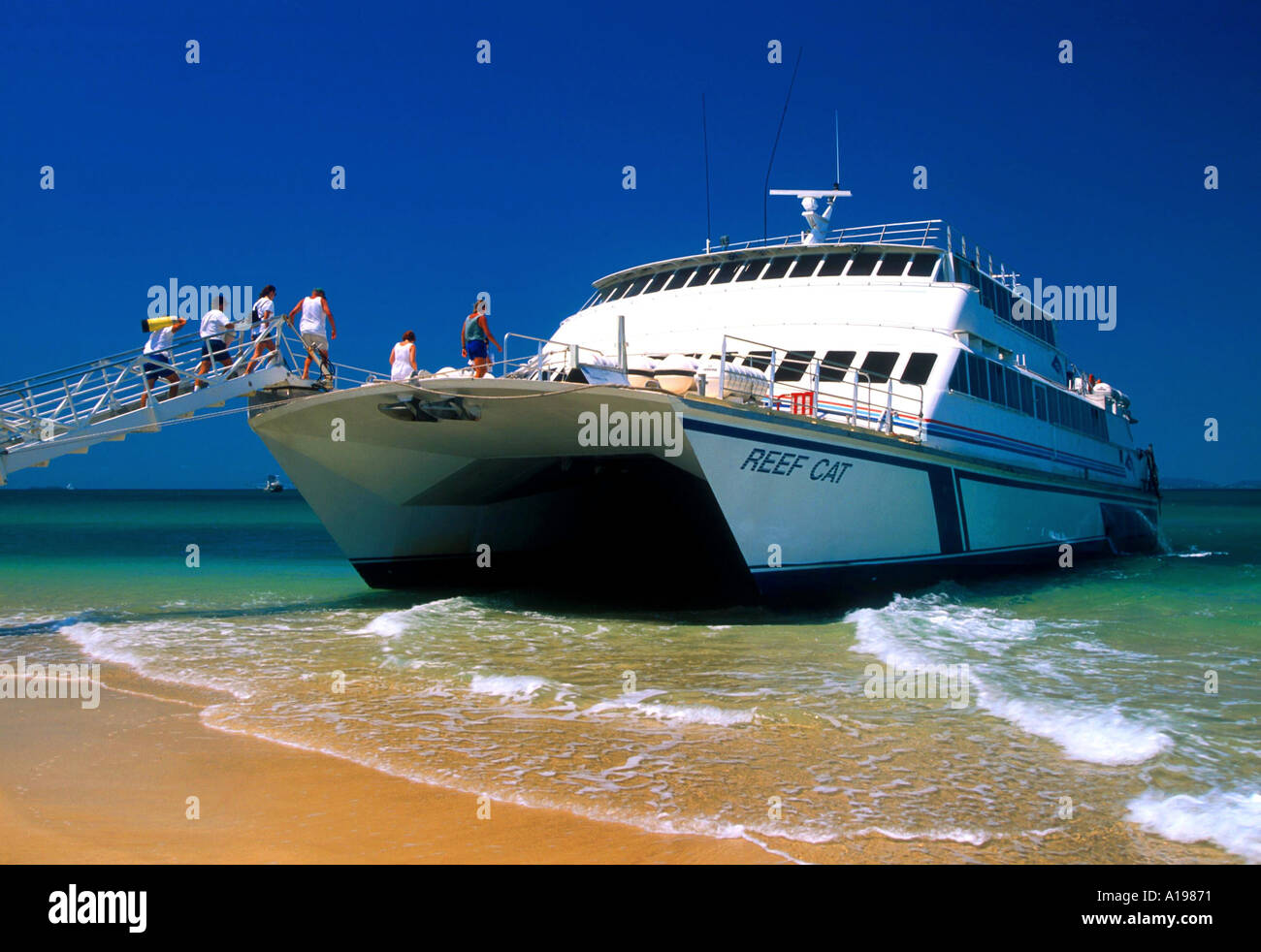 Tourists boarding large catamaran on beach near Rockhampton Queensland ...