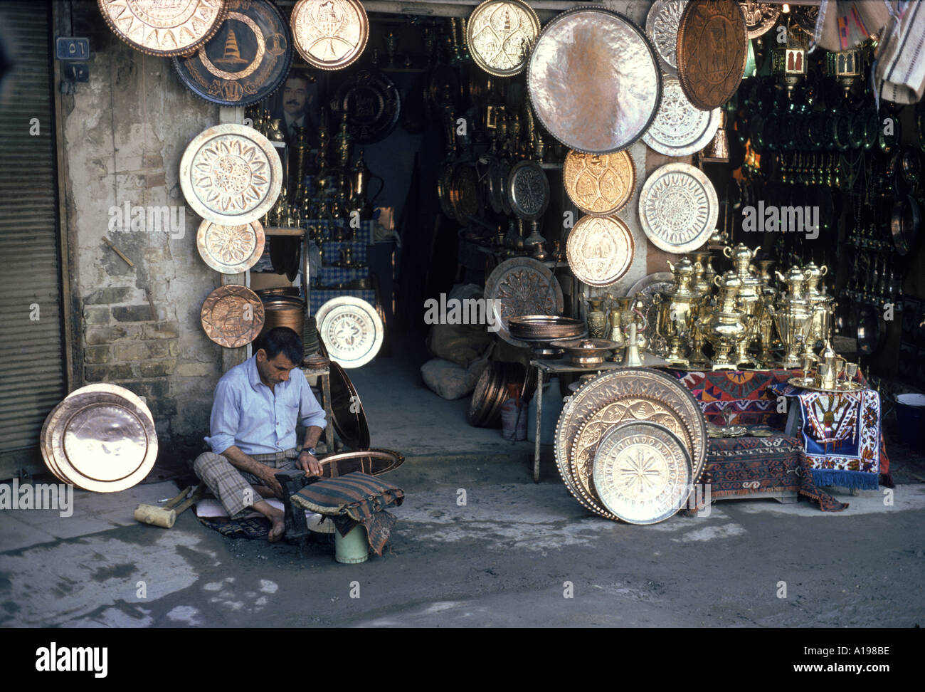 Man working on copper plate outside a copper souk Baghdad Iraq Middle ...