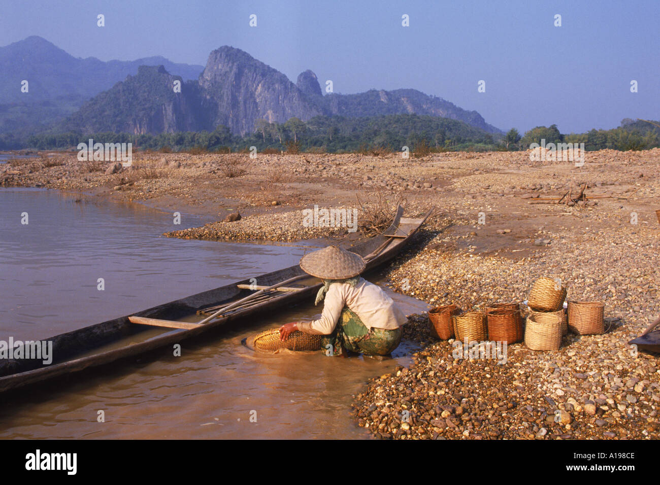 Woman panning for gold in the Mekong River at Pak Ou Laos Asia R McLeod ...
