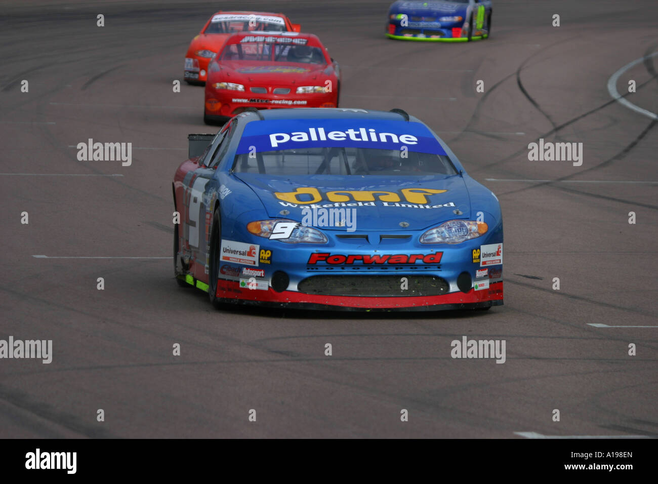 V8 Nascar type stock cars racing on a banked oval circuit Stock Photo ...