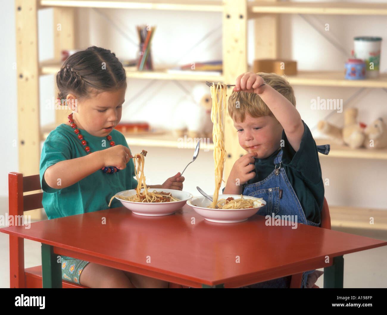 Boy and girl eating spaghetti together Stock Photo - Alamy