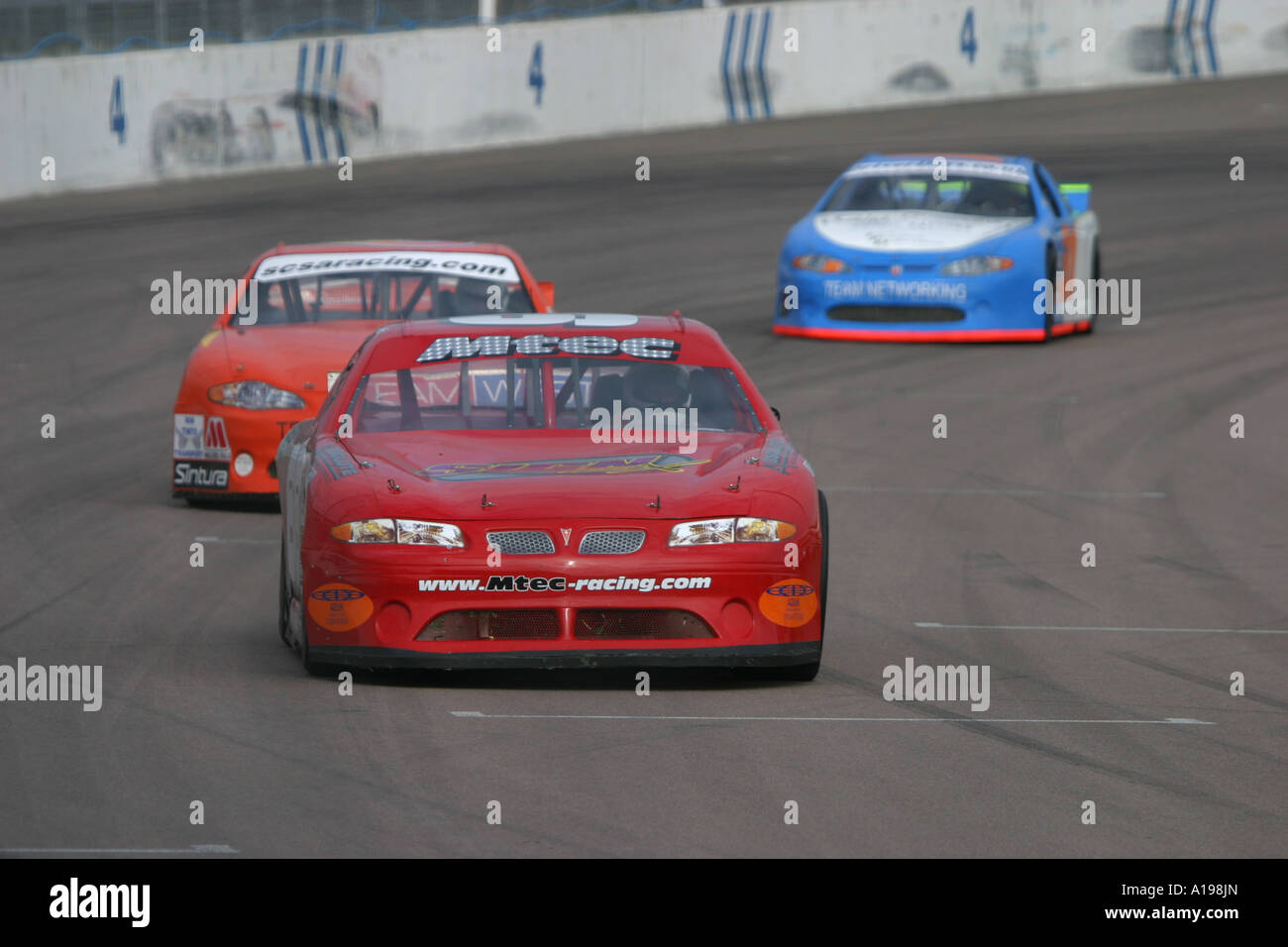 V8 Nascar type stock cars racing on a banked oval circuit Stock Photo ...