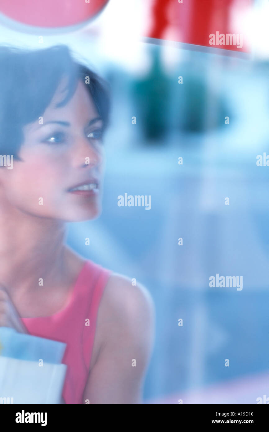 Woman shopper gazing through store window Stock Photo - Alamy