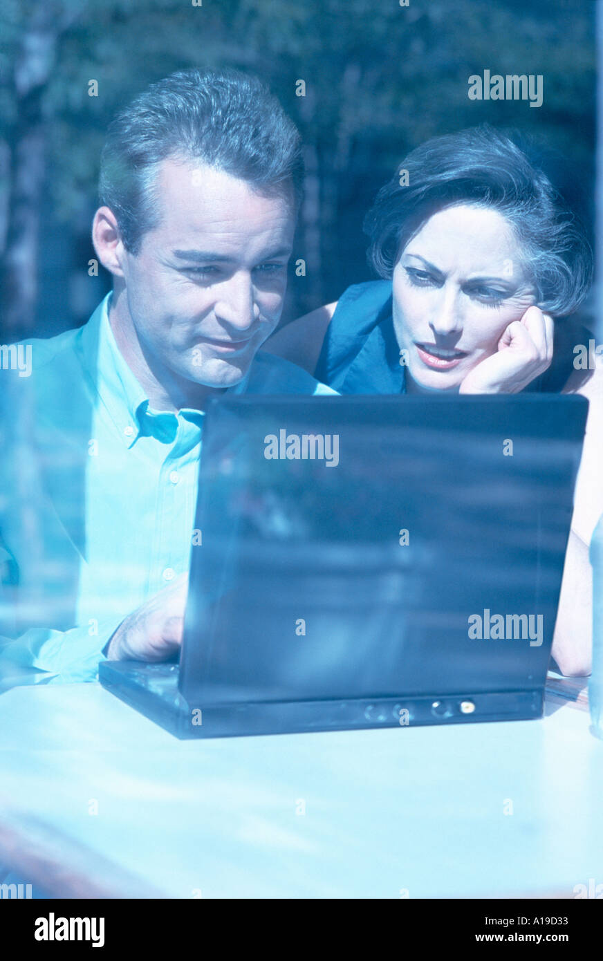Business partners working on laptop through window Stock Photo - Alamy