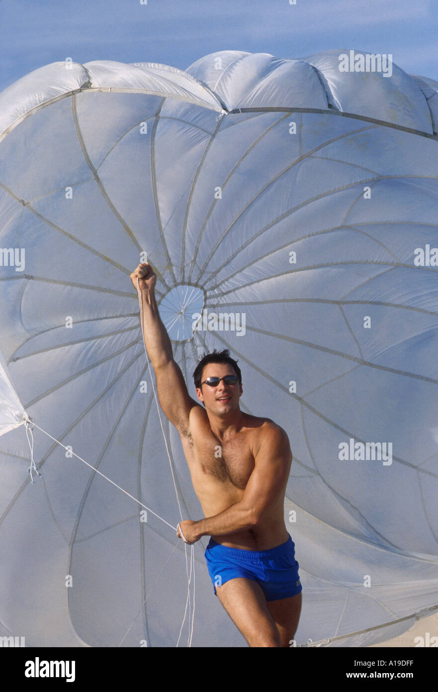 Man in swim suit with parachute Stock Photo - Alamy