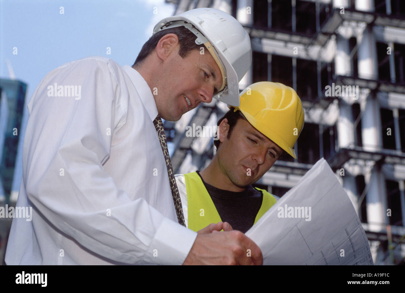 Architect with construction worker and blueprint Stock Photo - Alamy