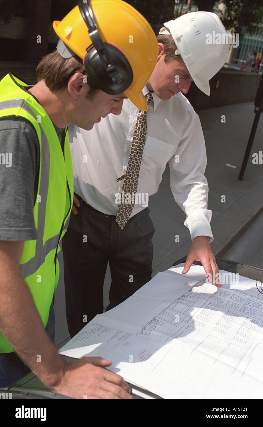 construction worker with engineer looking at blueprints Stock Photo - Alamy
