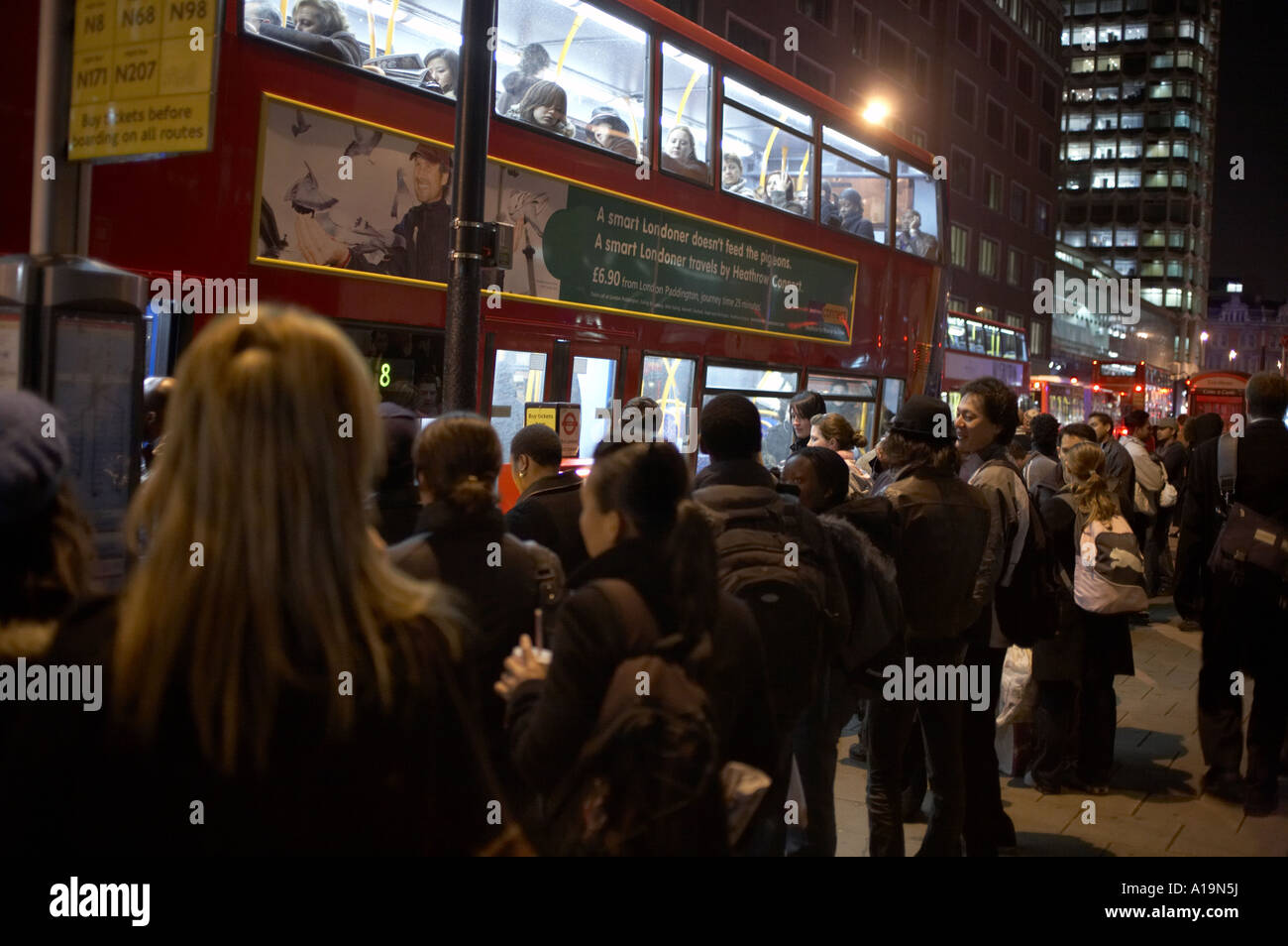commuters queue at bus stop in London UK Stock Photo - Alamy