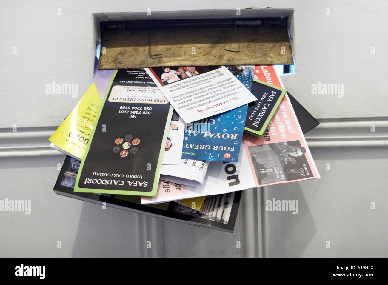 Junk mail through the postbox Stock Photo - Alamy