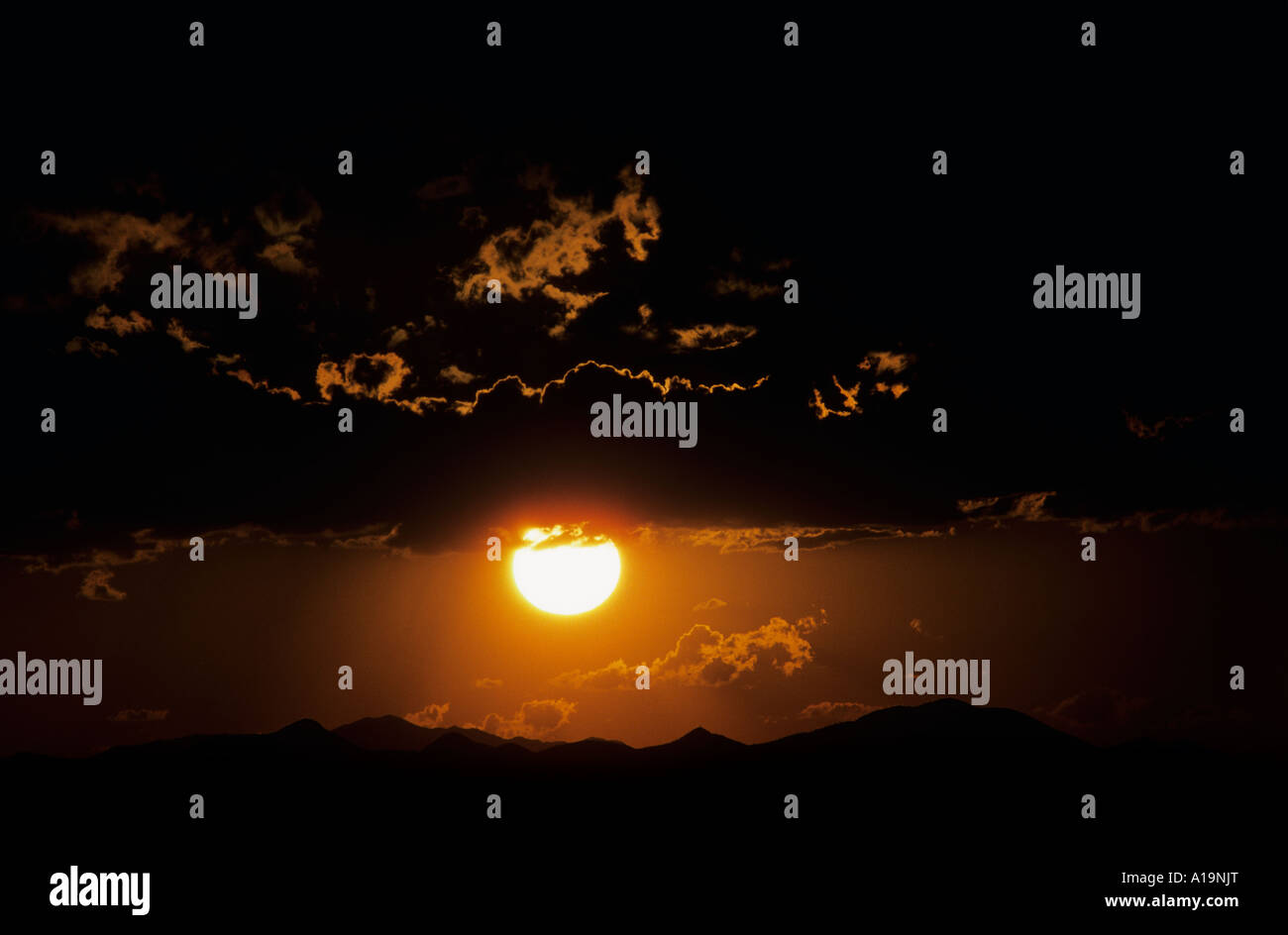 A large sun dips into the horizon at sunset Stock Photo - Alamy