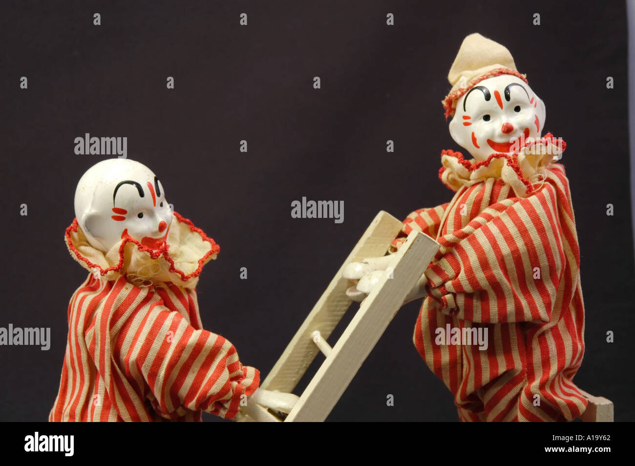 Two antique wooden circus clown toys holding onto a ladder Stock Photo ...