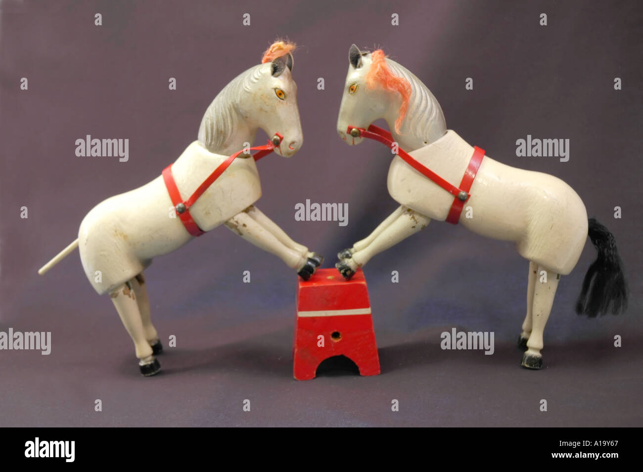 Two antique white wooden circus toy horses facing each other with their ...